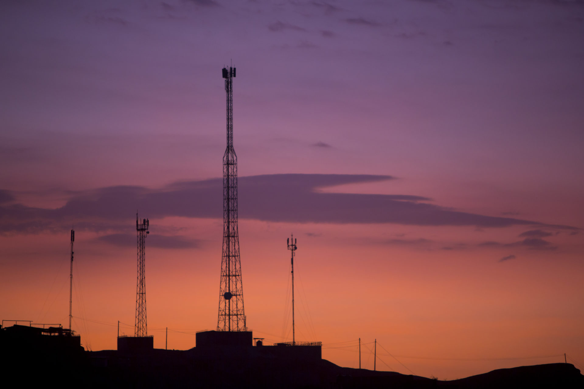 Communication towers on orange purple sky background, Peru | Nature of ...